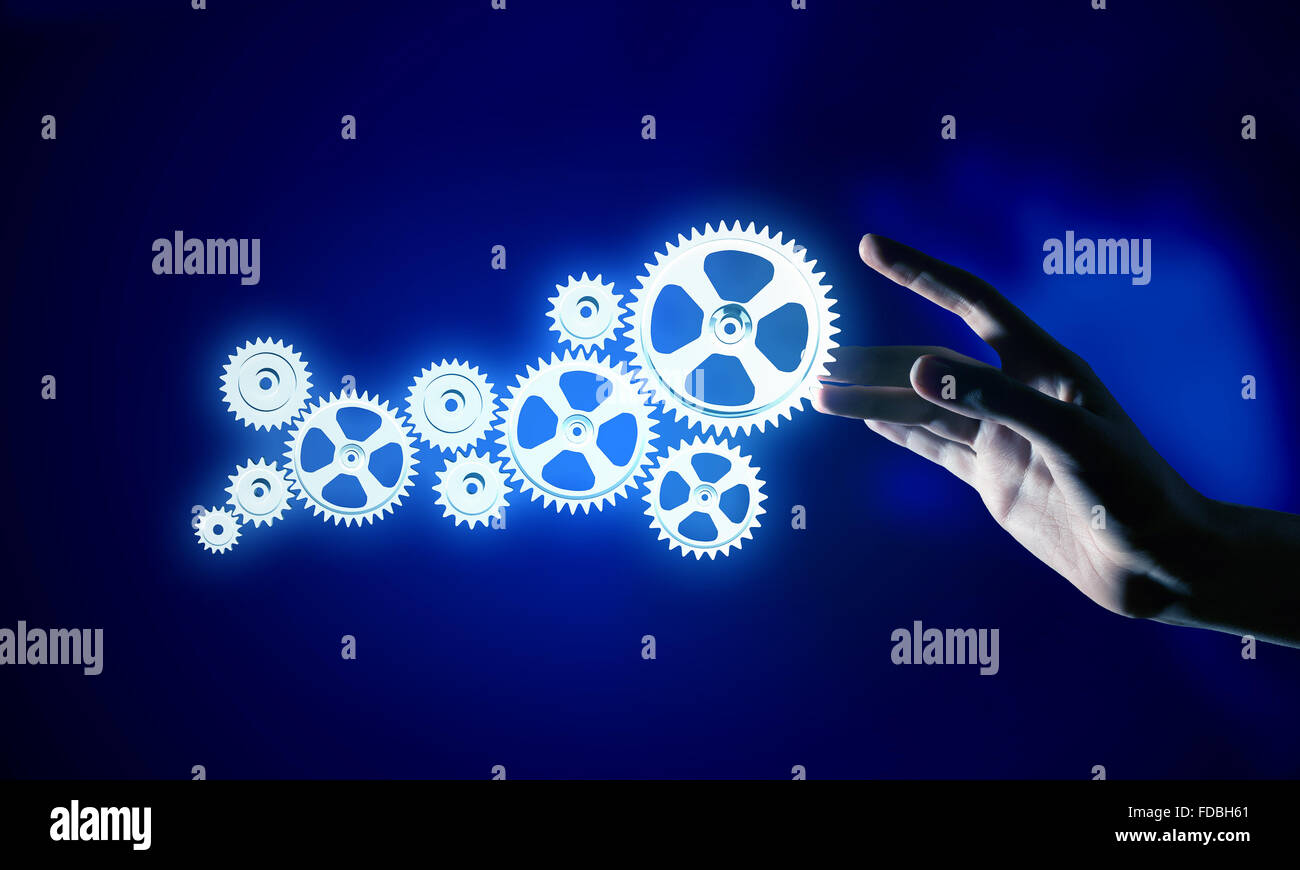 Business person hand touching gear mechanism representing interaction ...