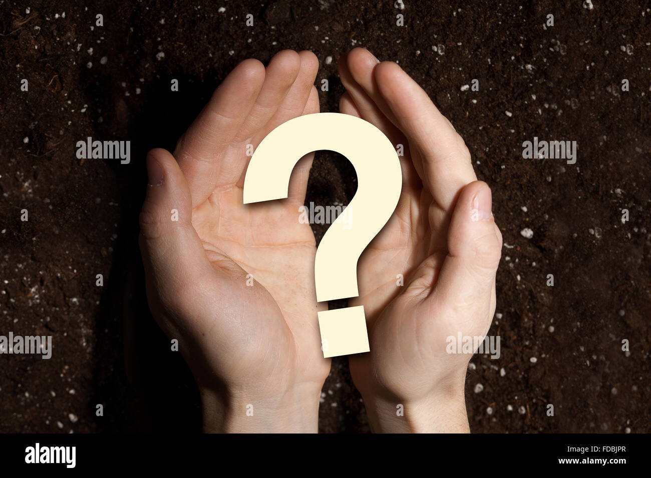 Question mark icon in male palms on soil background Stock Photo - Alamy