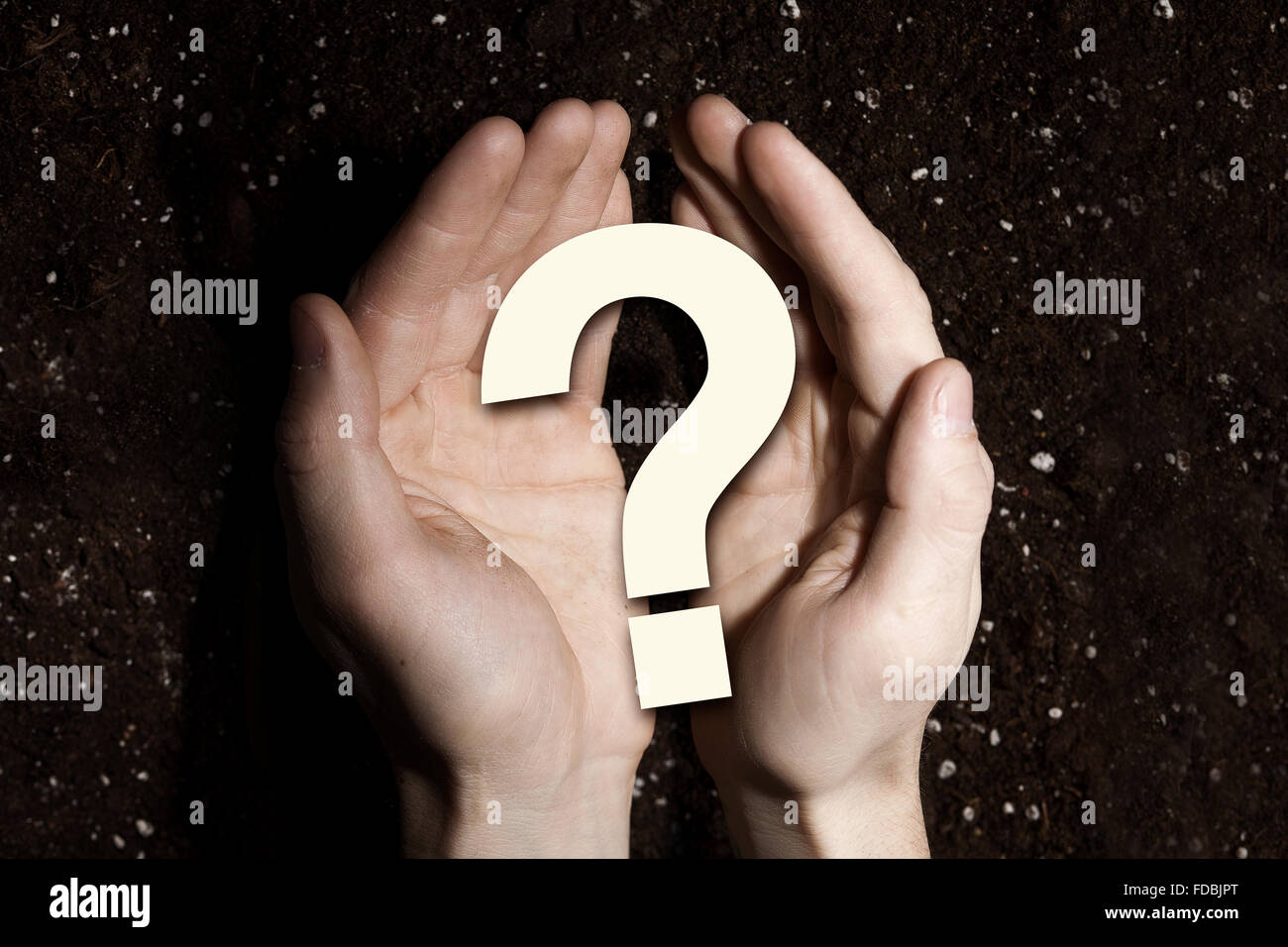 Question mark icon in male palms on soil background Stock Photo - Alamy