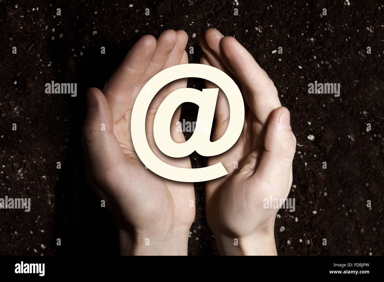 Close up of male hands showing email sign on soil background Stock ...