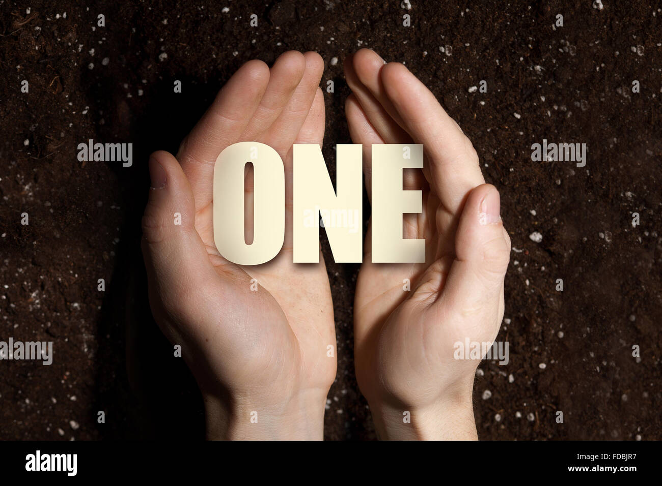 Male hands on soil background showing in palms word one Stock Photo - Alamy