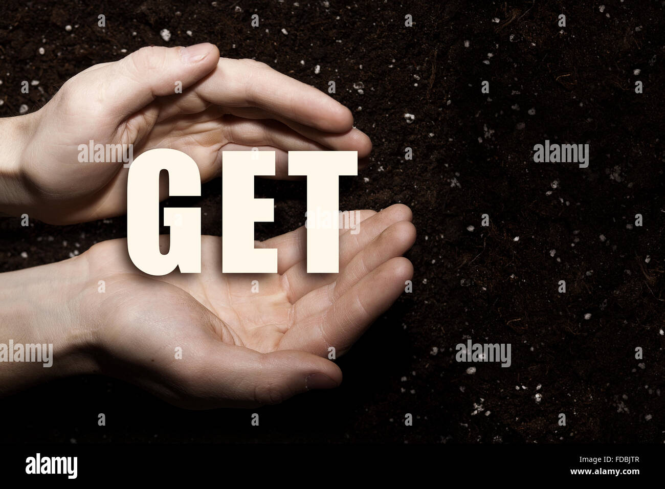 Male hands on soil background showing in palms word get Stock Photo - Alamy