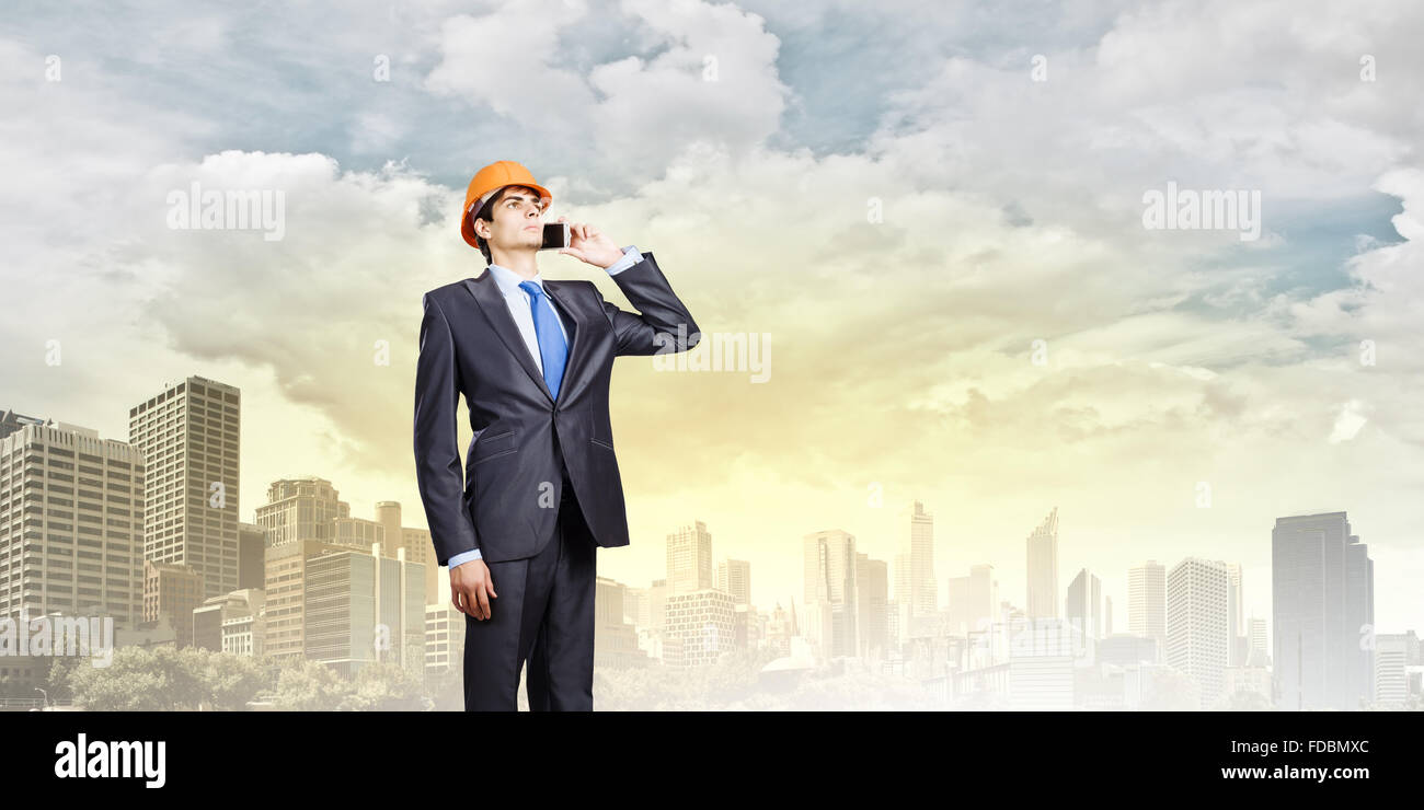 Young man engineer talking on mobile phone Stock Photo - Alamy