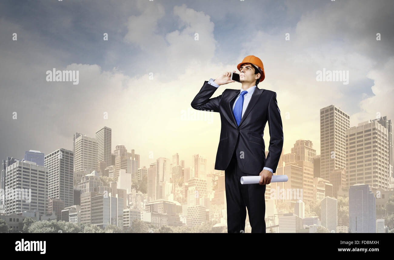 Young man engineer talking on mobile phone Stock Photo - Alamy