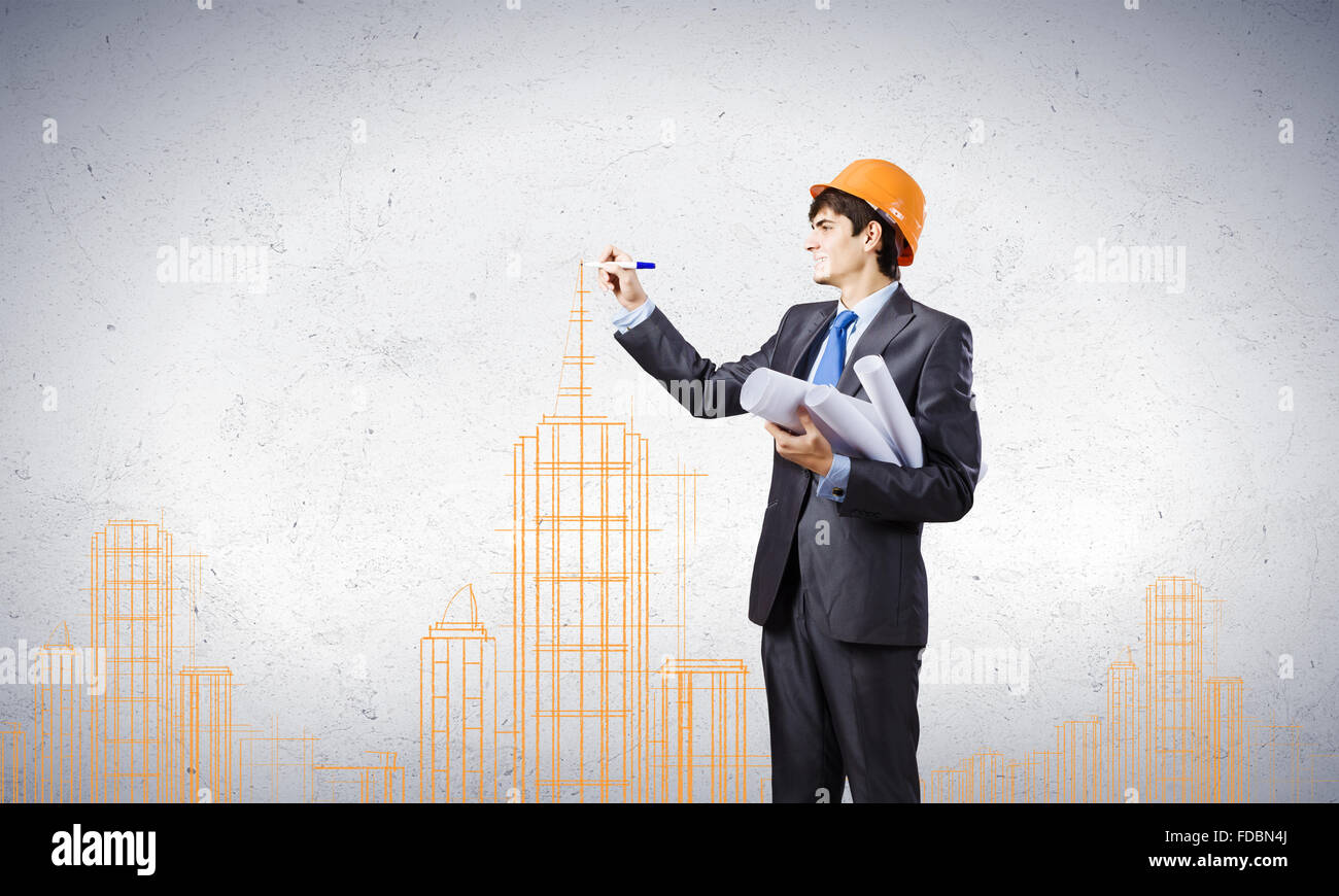 Young man engineer drawing sketches of construction project Stock Photo ...