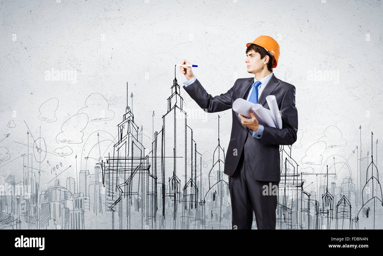 Young man engineer drawing sketches of construction project Stock Photo ...
