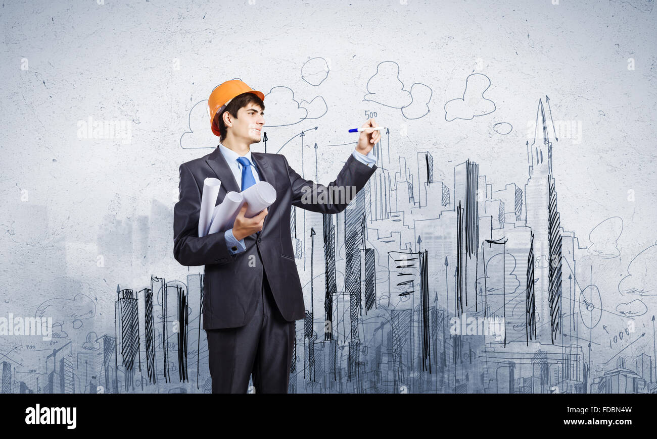 Young man engineer drawing sketches of construction project Stock Photo ...