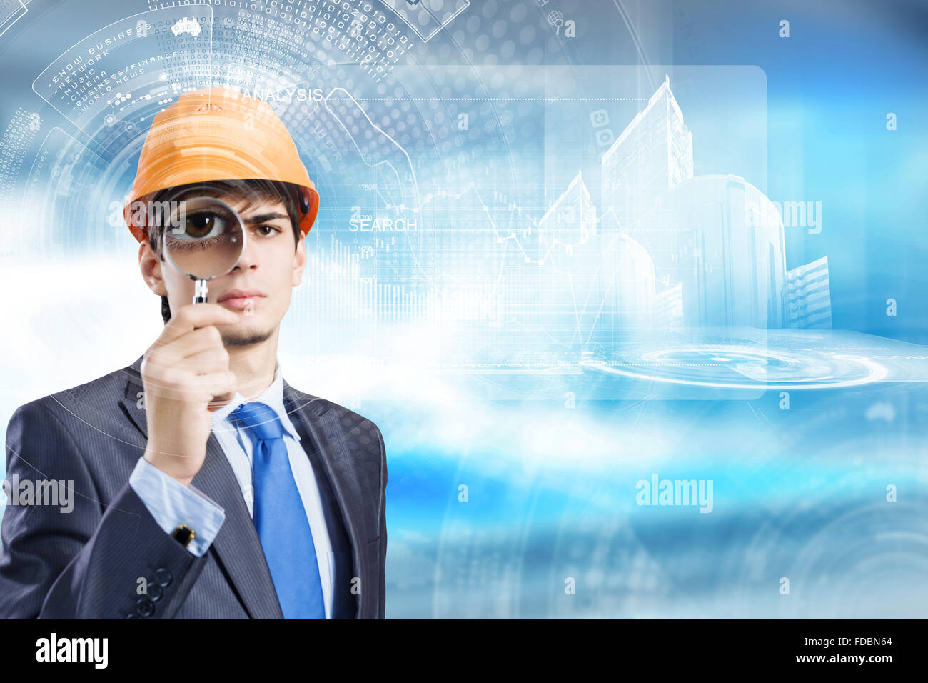 Young man engineer against media background looking in magnifying glass ...