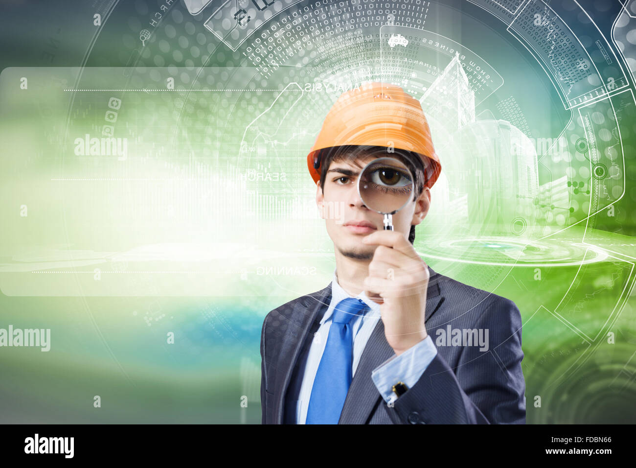 Young man engineer against media background looking in magnifying glass ...