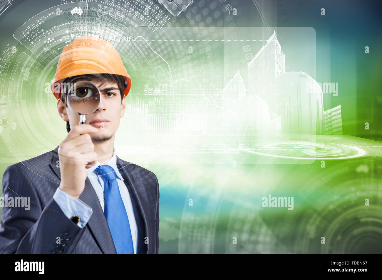 Young man engineer against media background looking in magnifying glass ...
