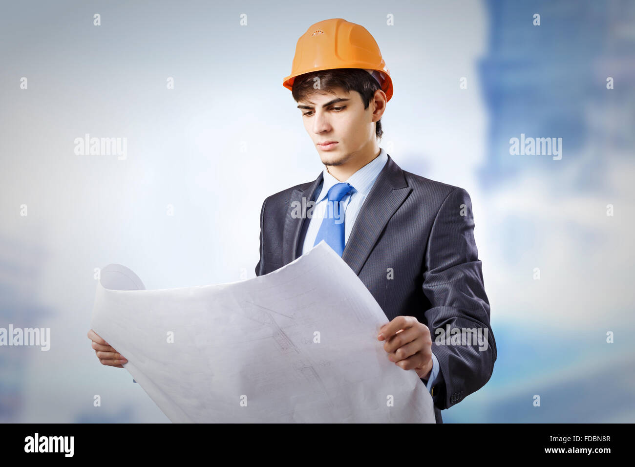 Young man architect looking at construction project Stock Photo - Alamy