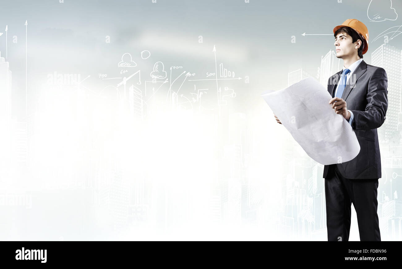 Young man architect looking at construction project Stock Photo - Alamy