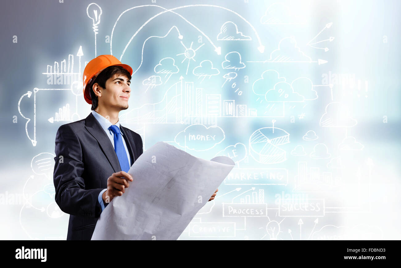 Young man architect looking at construction project Stock Photo - Alamy