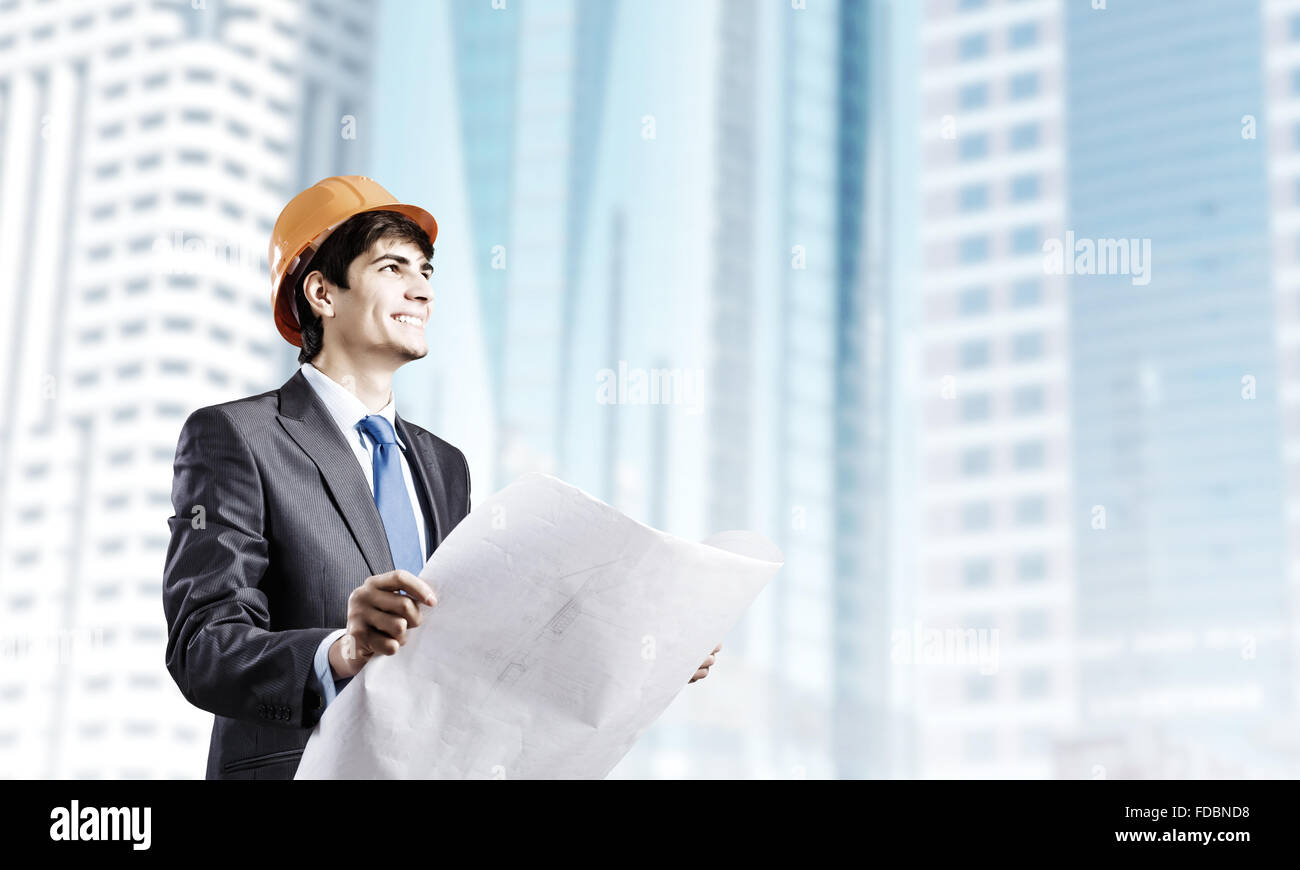 Young man architect looking at construction project Stock Photo - Alamy