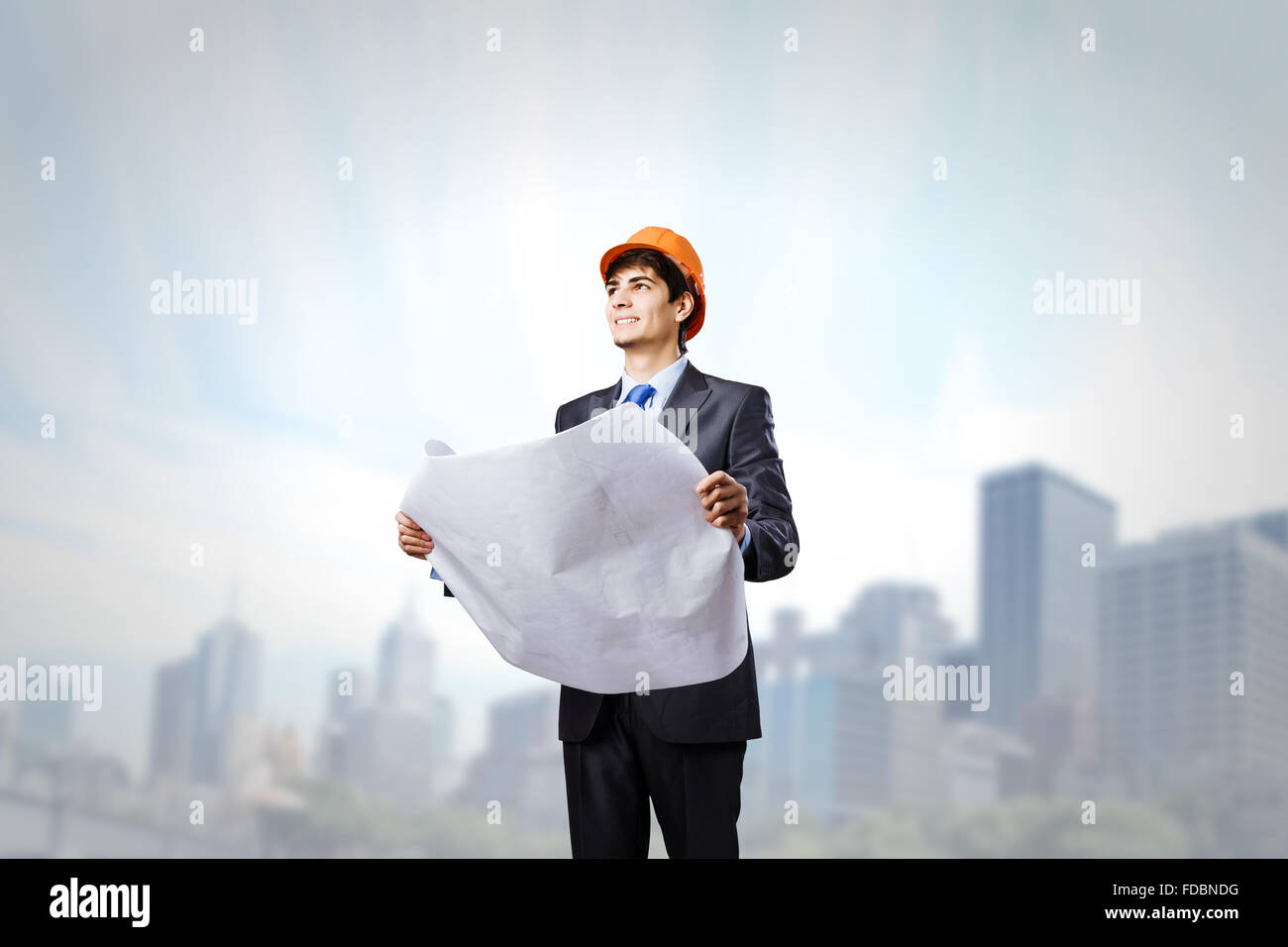 Young man architect looking at construction project Stock Photo - Alamy