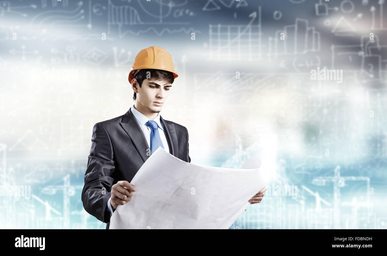 Young man architect looking at construction project Stock Photo - Alamy
