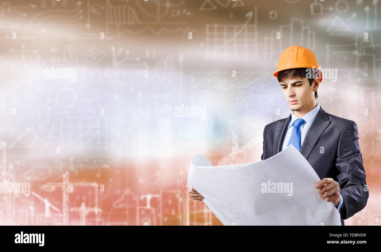 Young man architect looking at construction project Stock Photo - Alamy