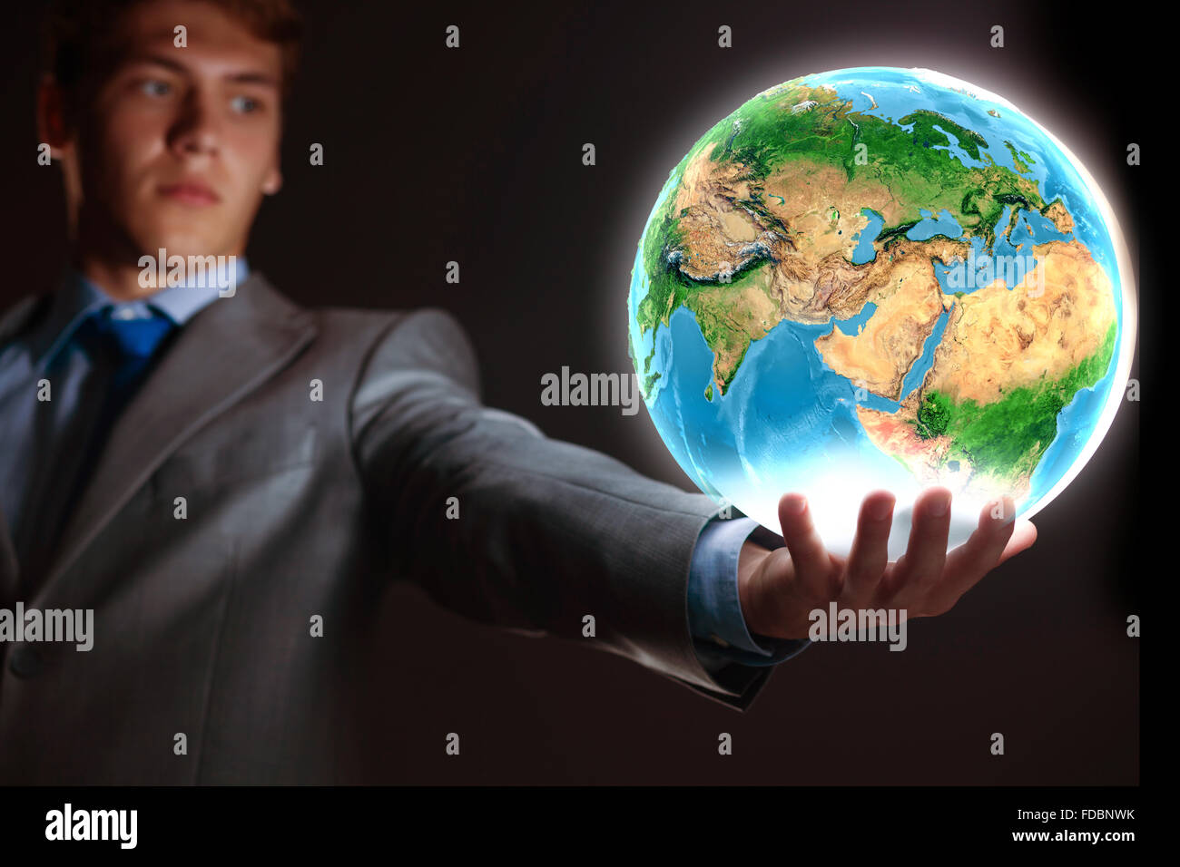 Young businessman holding Earth planet in hand. Elements of this image ...