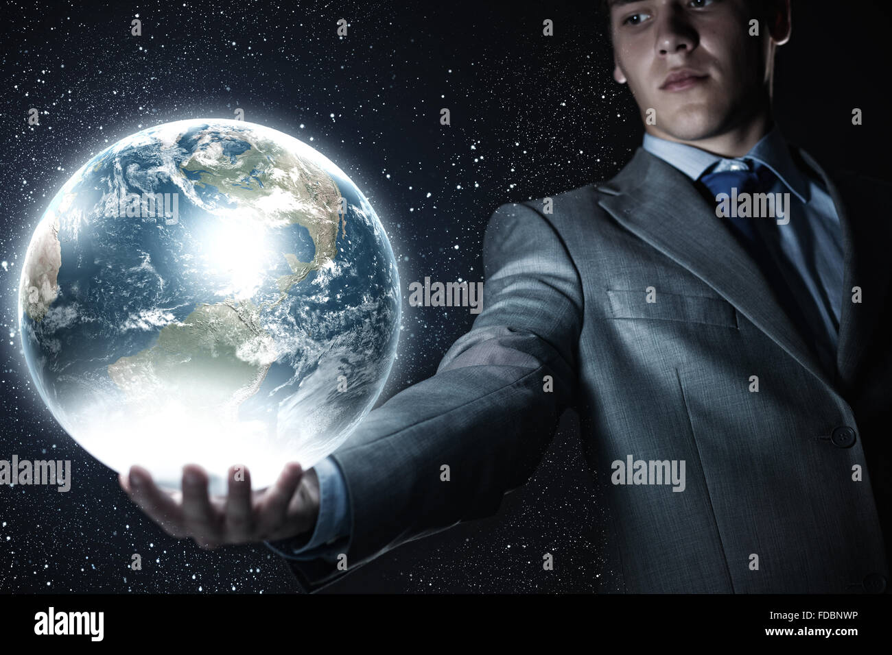 Young businessman holding Earth planet in hand. Elements of this image ...