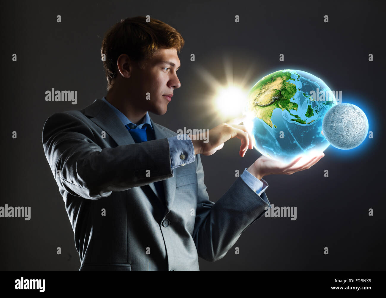 Young businessman holding Earth planet in hand. Elements of this image ...