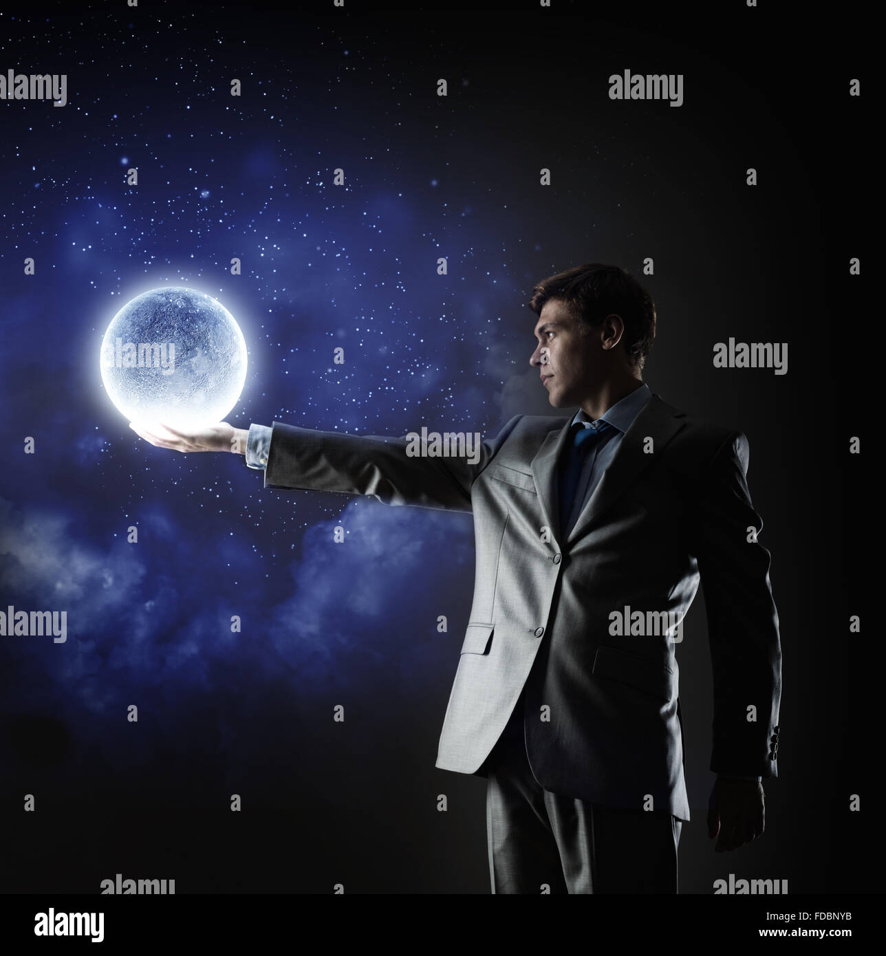 Young businessman holding moon planet in hand Stock Photo - Alamy
