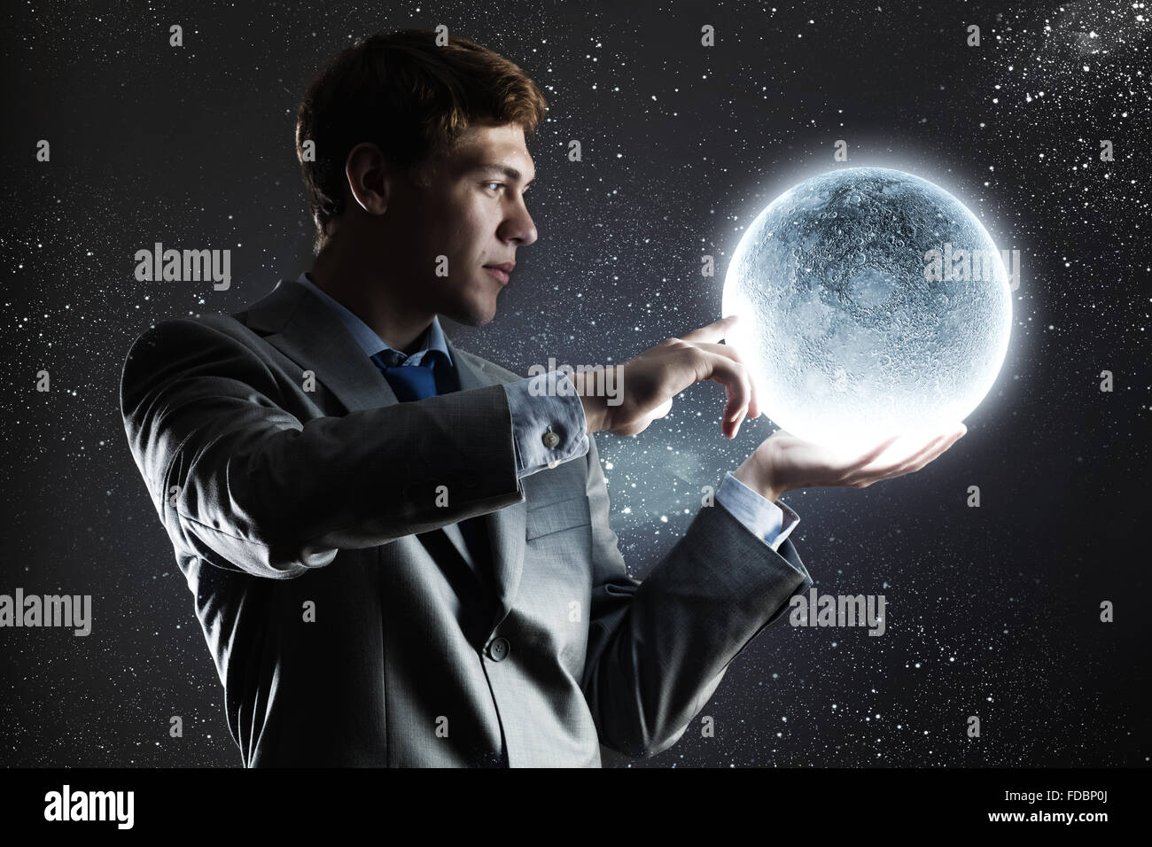 Young businessman holding moon planet in hand Stock Photo - Alamy