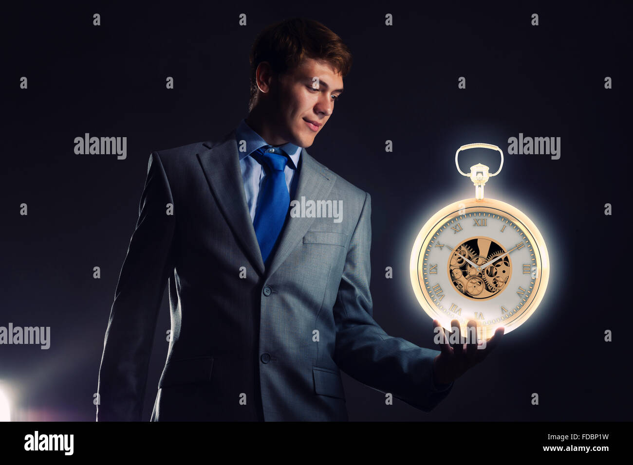 Young businessman holding pocket watch in hand Stock Photo - Alamy