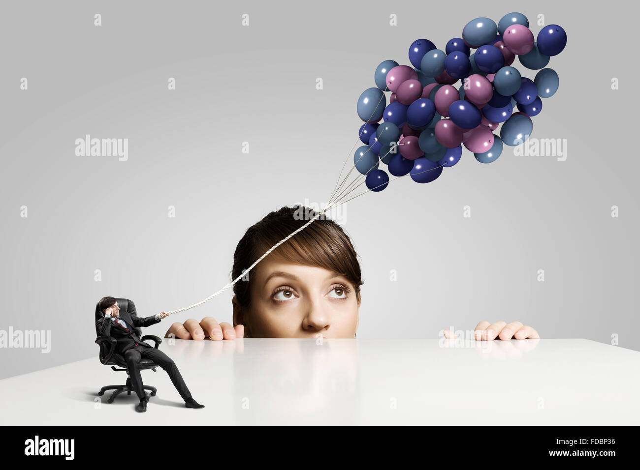 Businesswoman looking from under the table at businessman miniature ...
