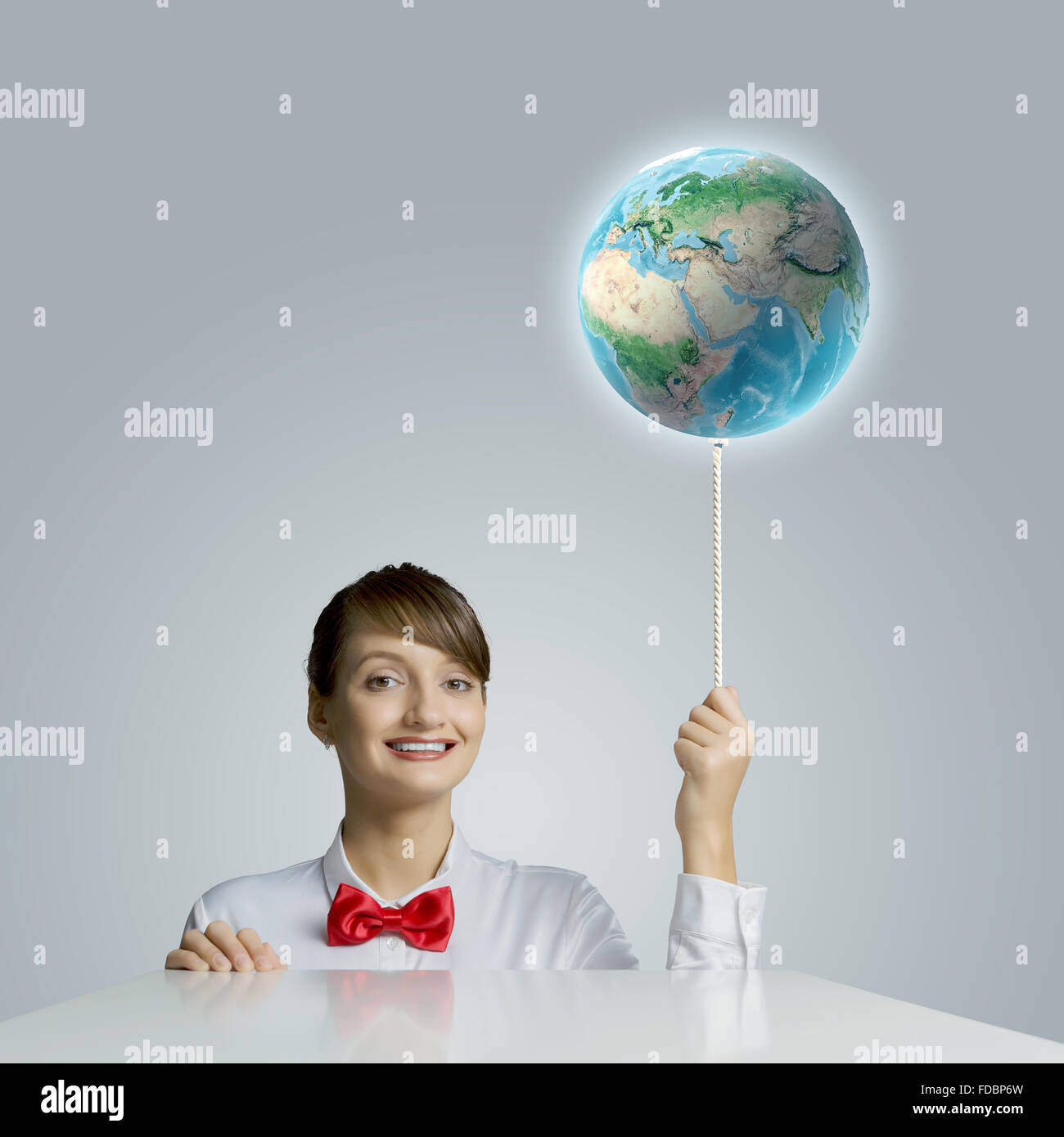 Young smiling woman holding balloon colored like Earth planet. Elements ...