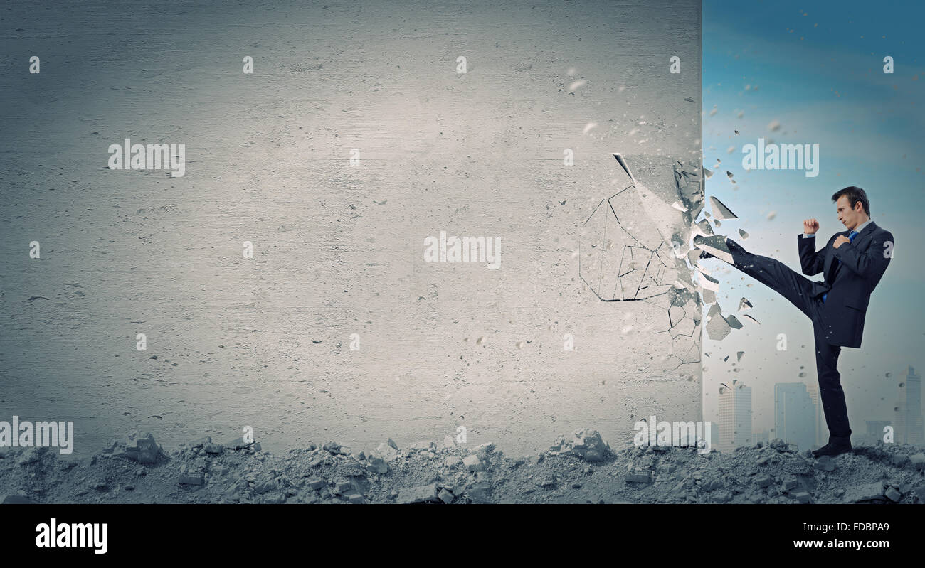 Businessman breaking stone wall with karate kick hi-res stock ...