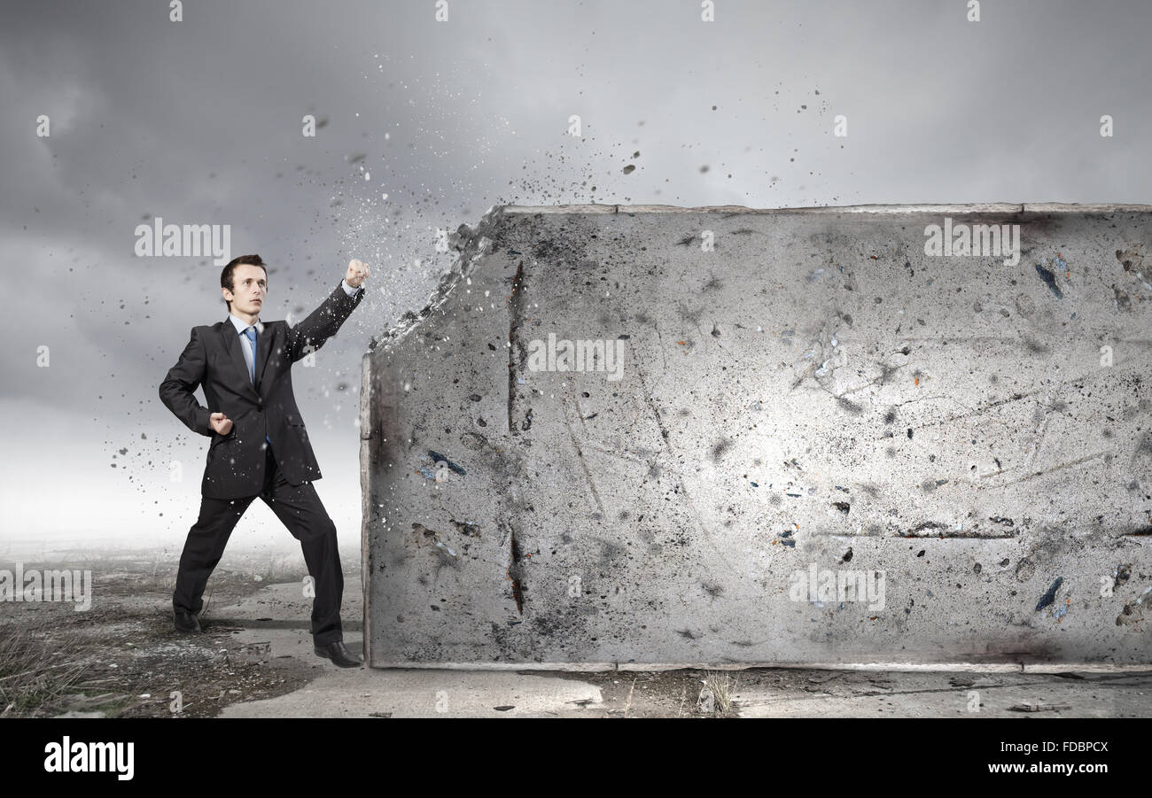 Businessman breaking stone wall with karate punch Stock Photo - Alamy