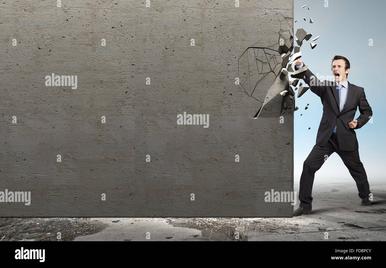 Businessman breaking stone wall with karate punch Stock Photo - Alamy