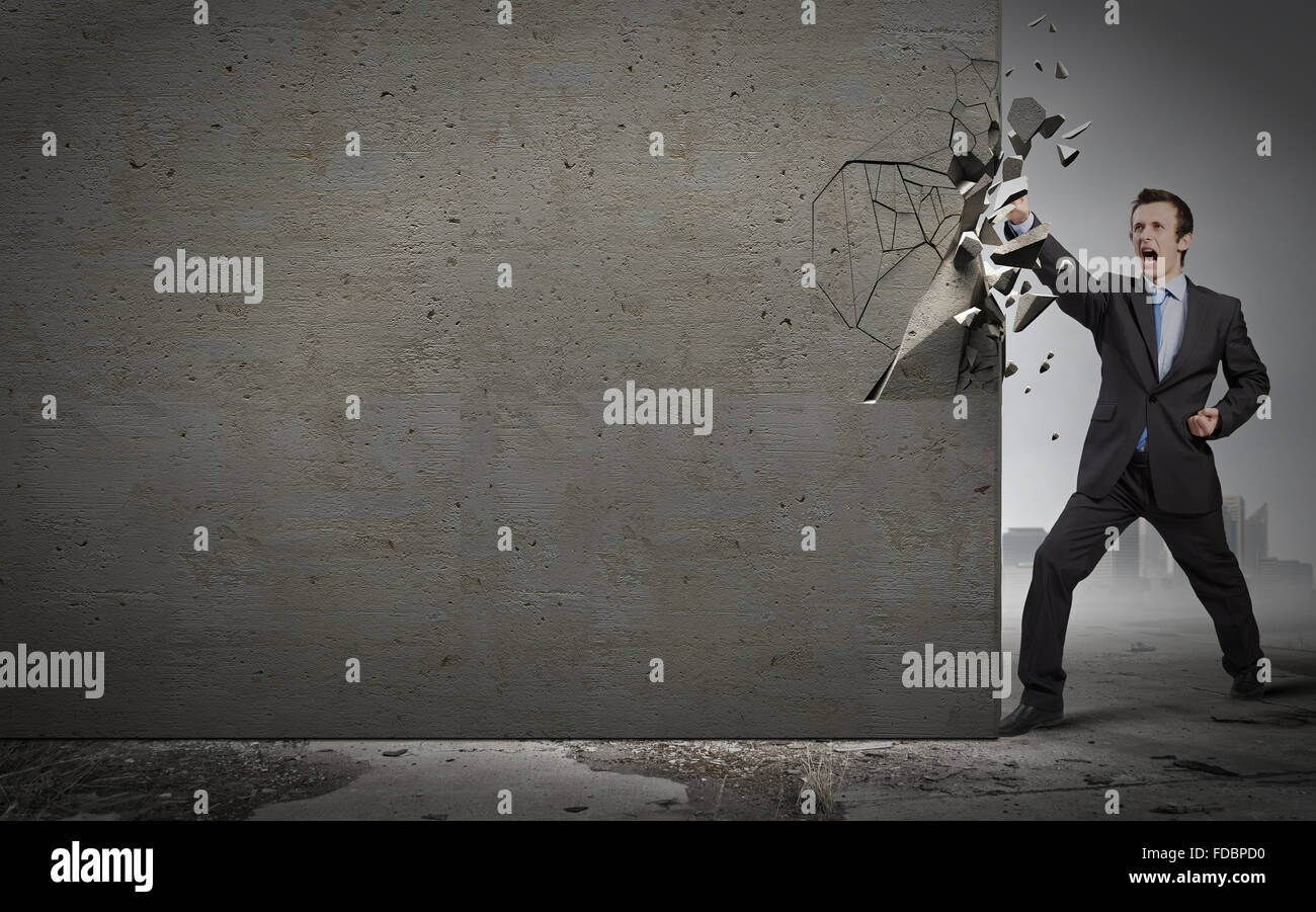 Businessman breaking stone wall with karate punch Stock Photo - Alamy
