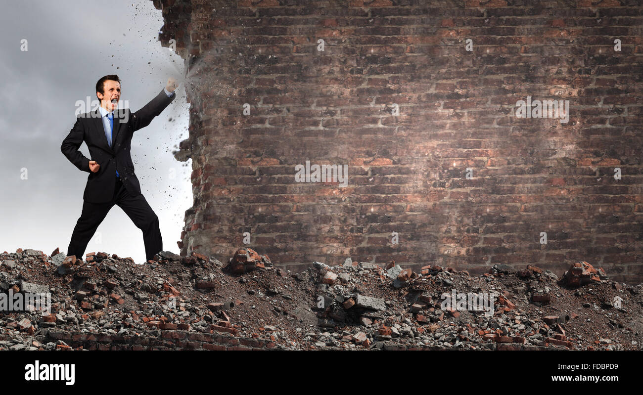 Businessman breaking stone wall with karate punch Stock Photo - Alamy