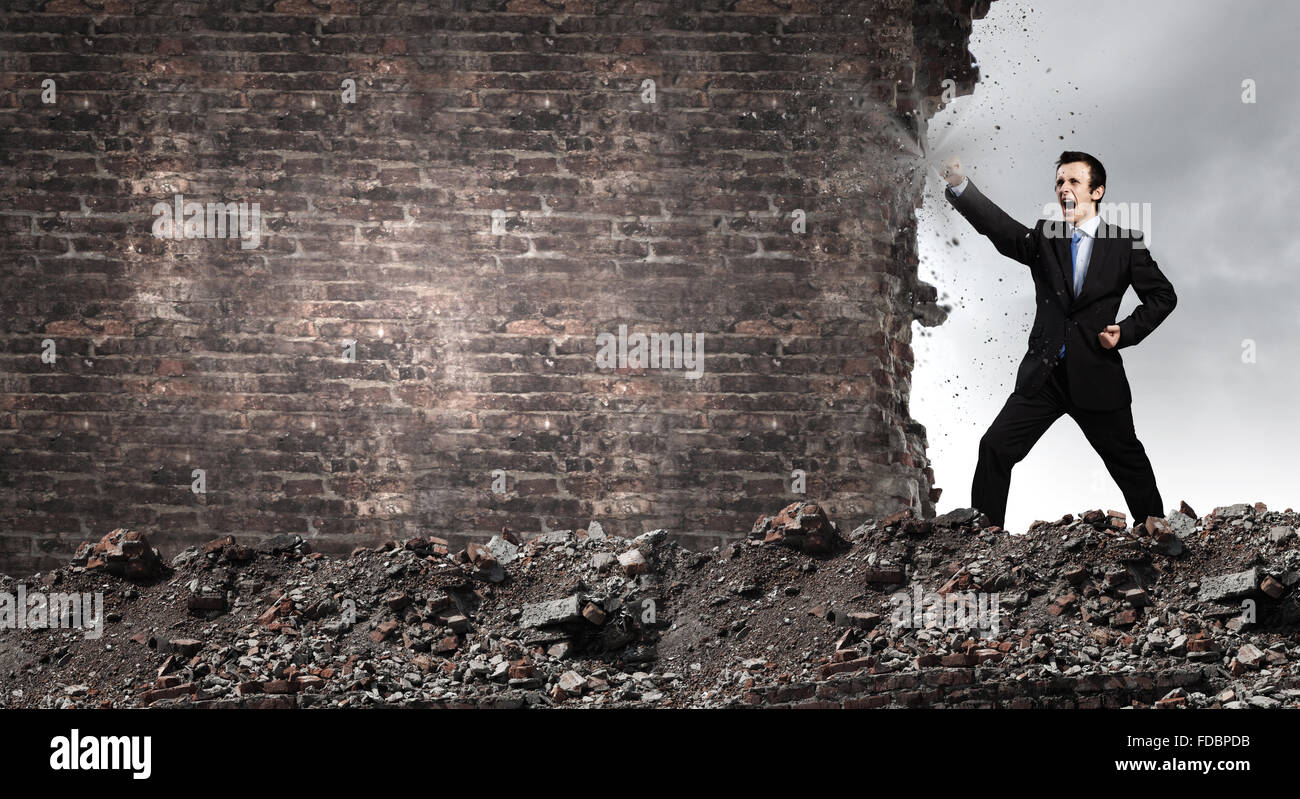 Businessman breaking stone wall with karate punch Stock Photo - Alamy