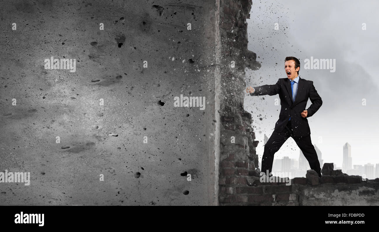 Businessman breaking stone wall with karate punch Stock Photo - Alamy