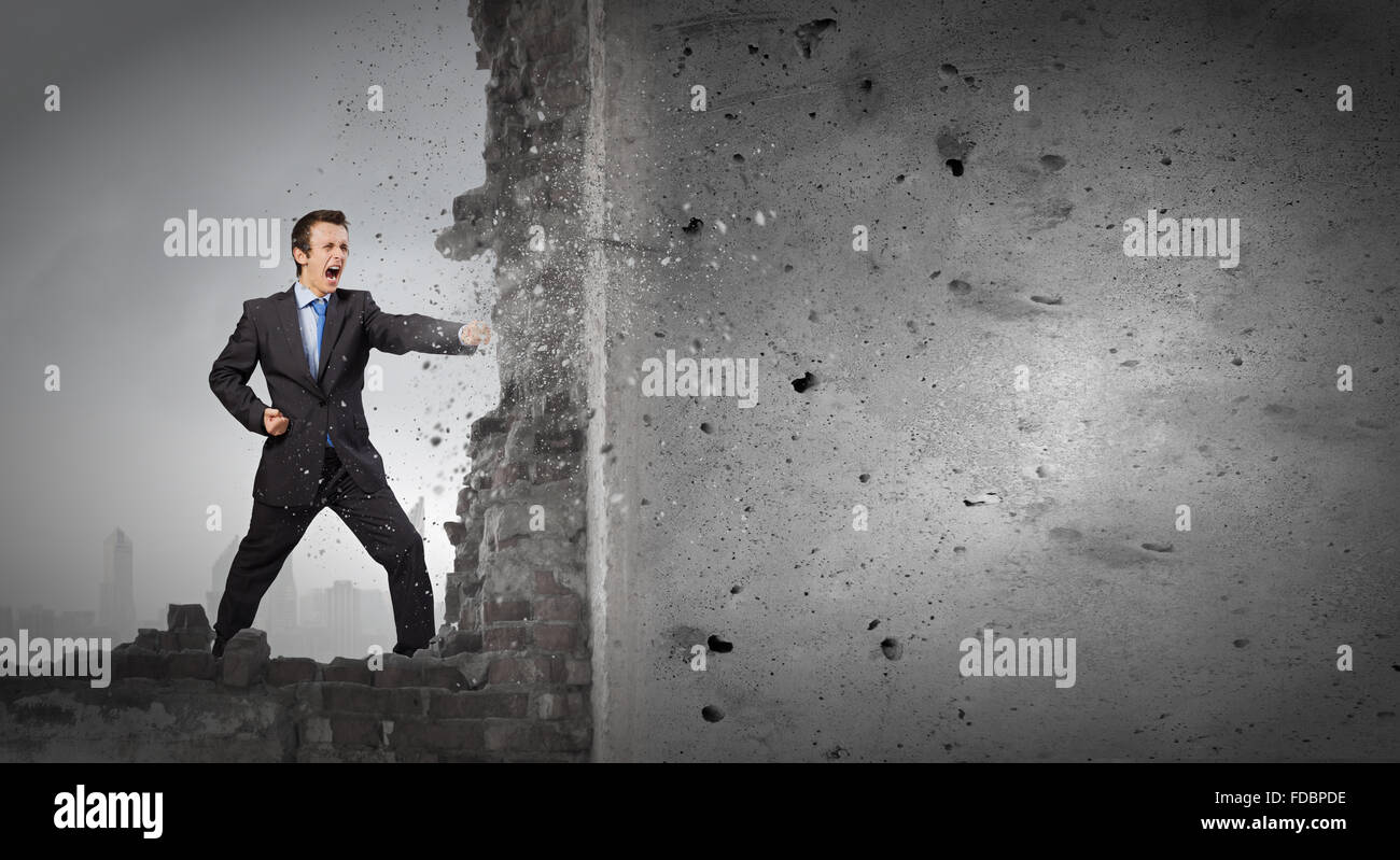 Businessman breaking stone wall with karate punch Stock Photo - Alamy