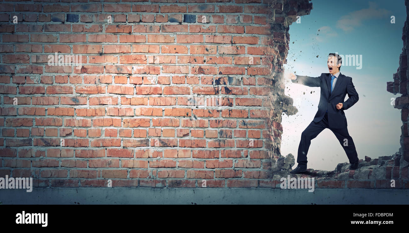 Businessman breaking stone wall with karate punch Stock Photo - Alamy