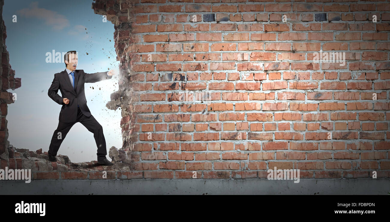 Businessman breaking stone wall with karate punch Stock Photo - Alamy