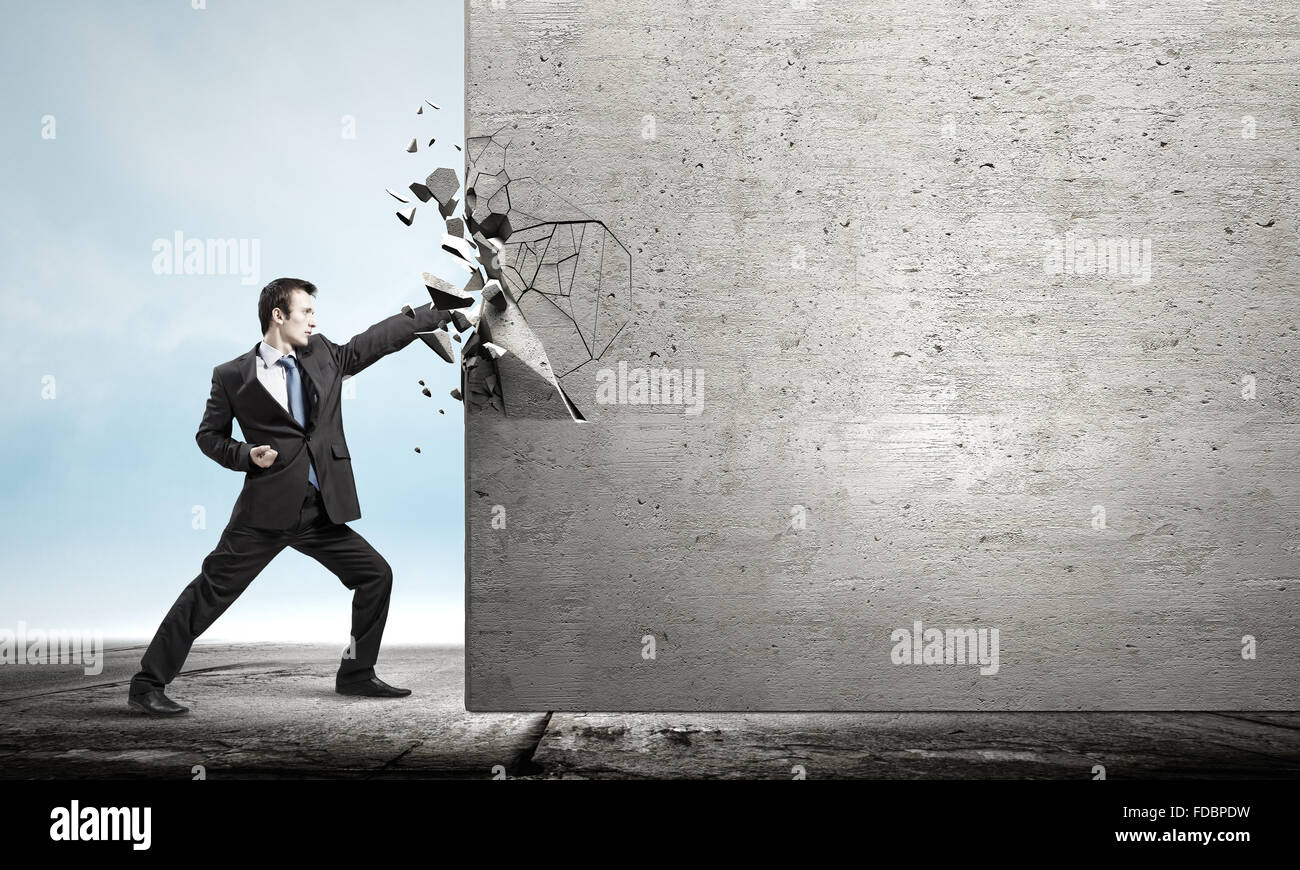 Businessman breaking stone wall with karate punch Stock Photo - Alamy
