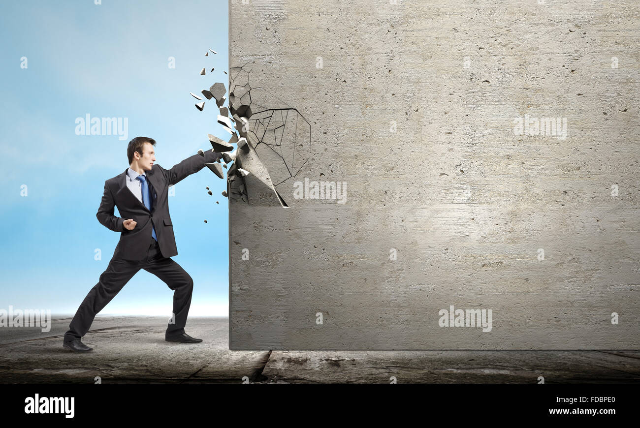 Businessman breaking stone wall with karate punch Stock Photo - Alamy