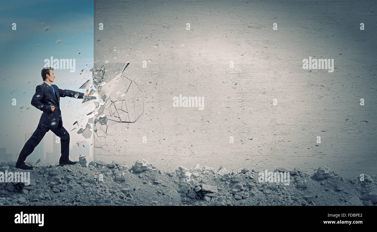 Businessman breaking stone wall with karate punch Stock Photo - Alamy