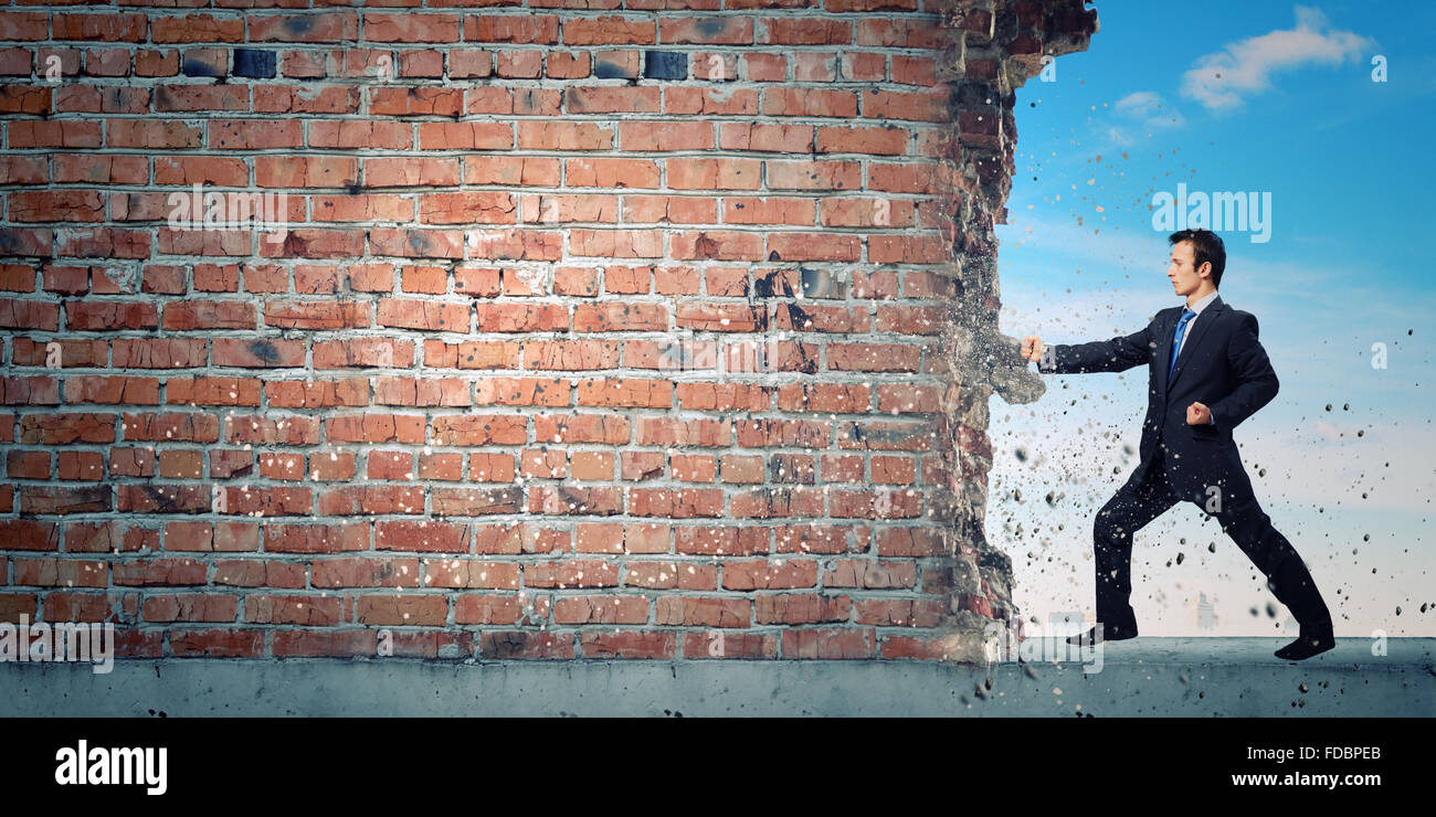 Businessman breaking stone wall with karate punch Stock Photo - Alamy