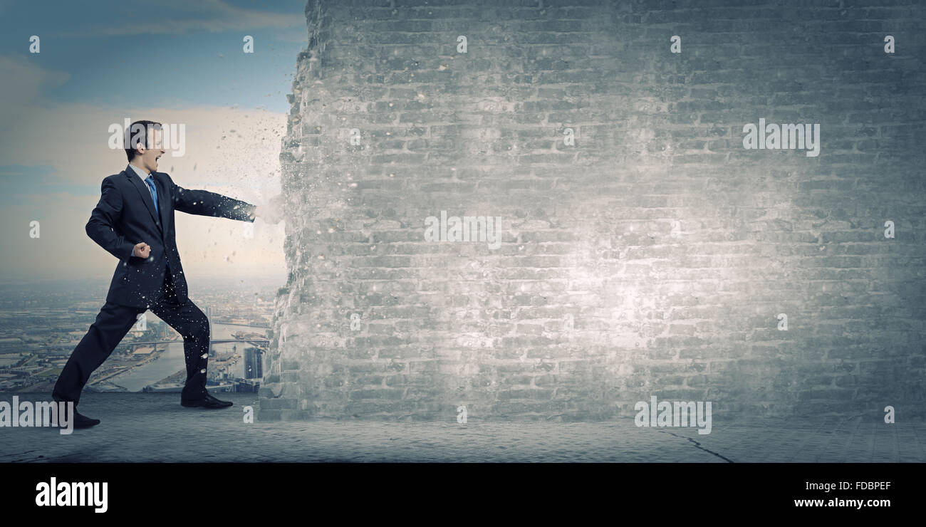 Businessman breaking stone wall with karate punch Stock Photo - Alamy