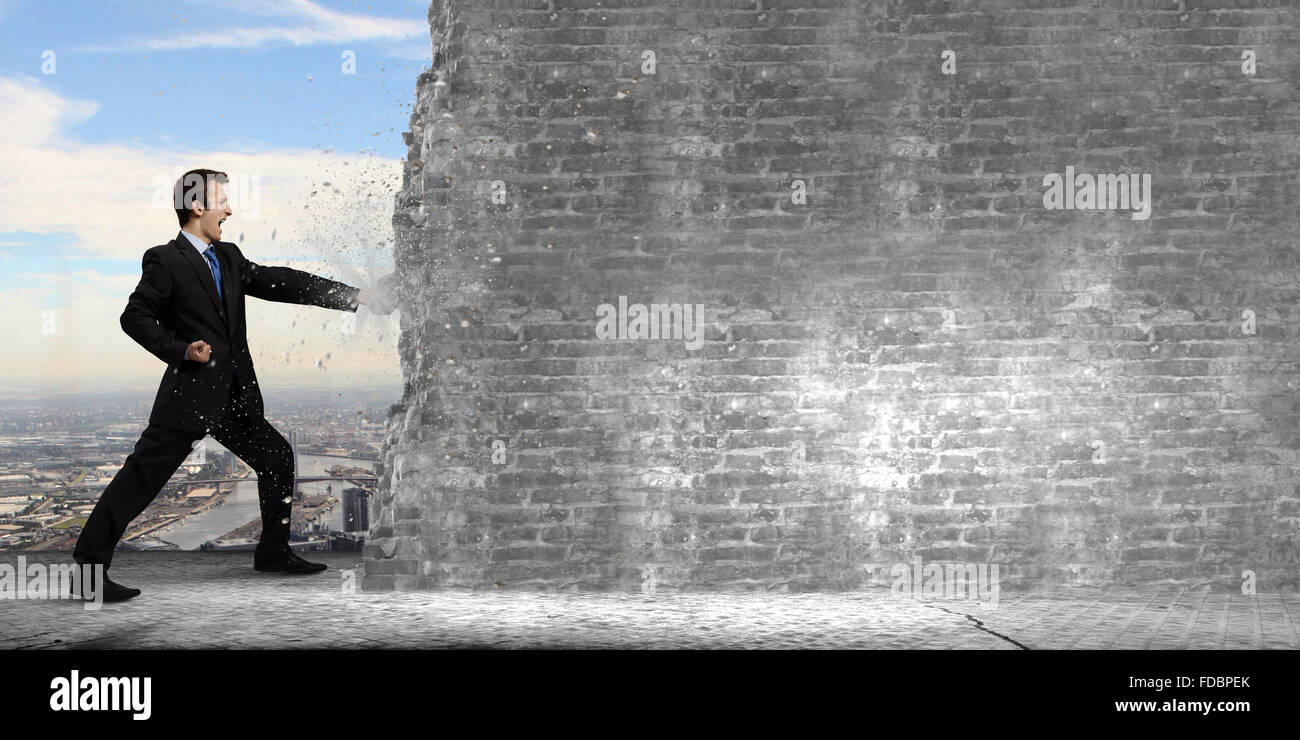 Businessman breaking stone wall with karate punch Stock Photo - Alamy