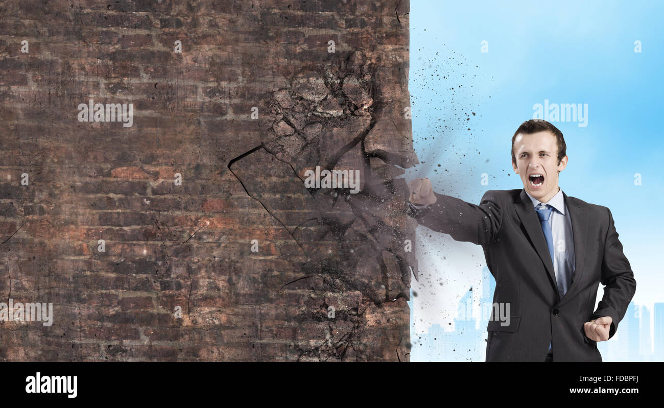 Businessman breaking stone wall with karate punch Stock Photo - Alamy