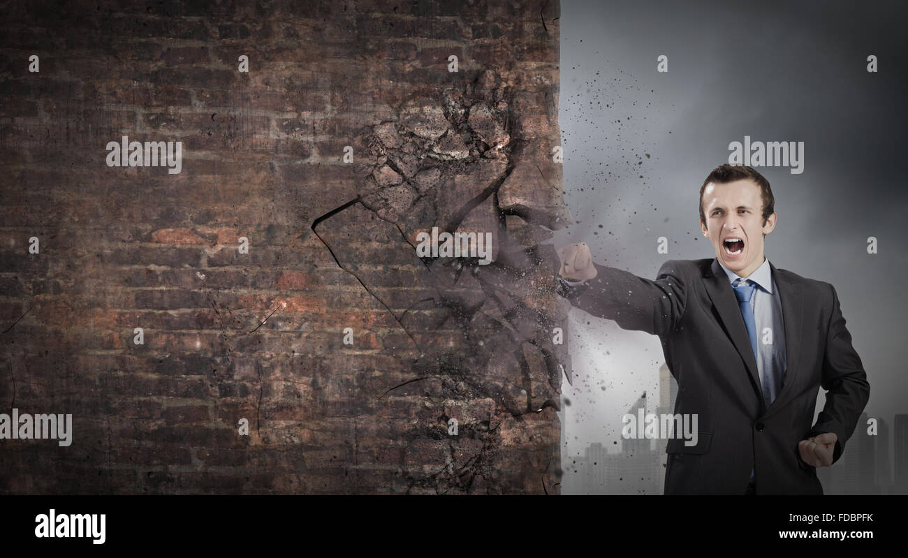 Businessman breaking stone wall with karate punch Stock Photo - Alamy