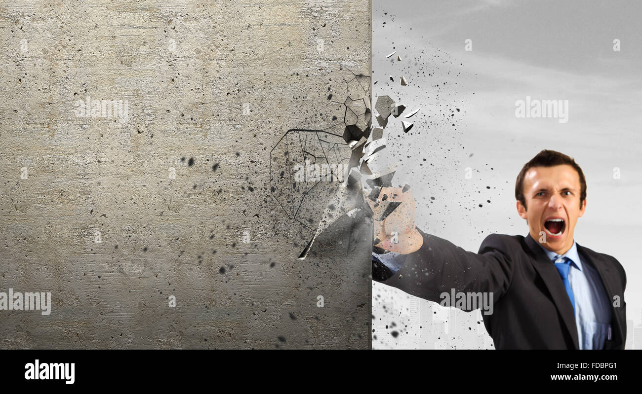Businessman breaking stone wall with karate punch Stock Photo - Alamy