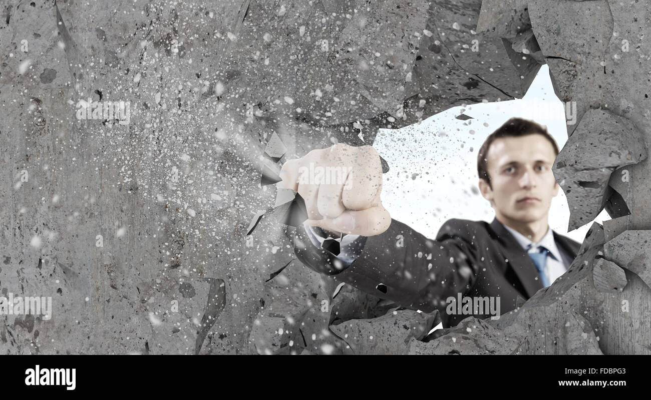Businessman breaking stone wall with karate punch Stock Photo - Alamy