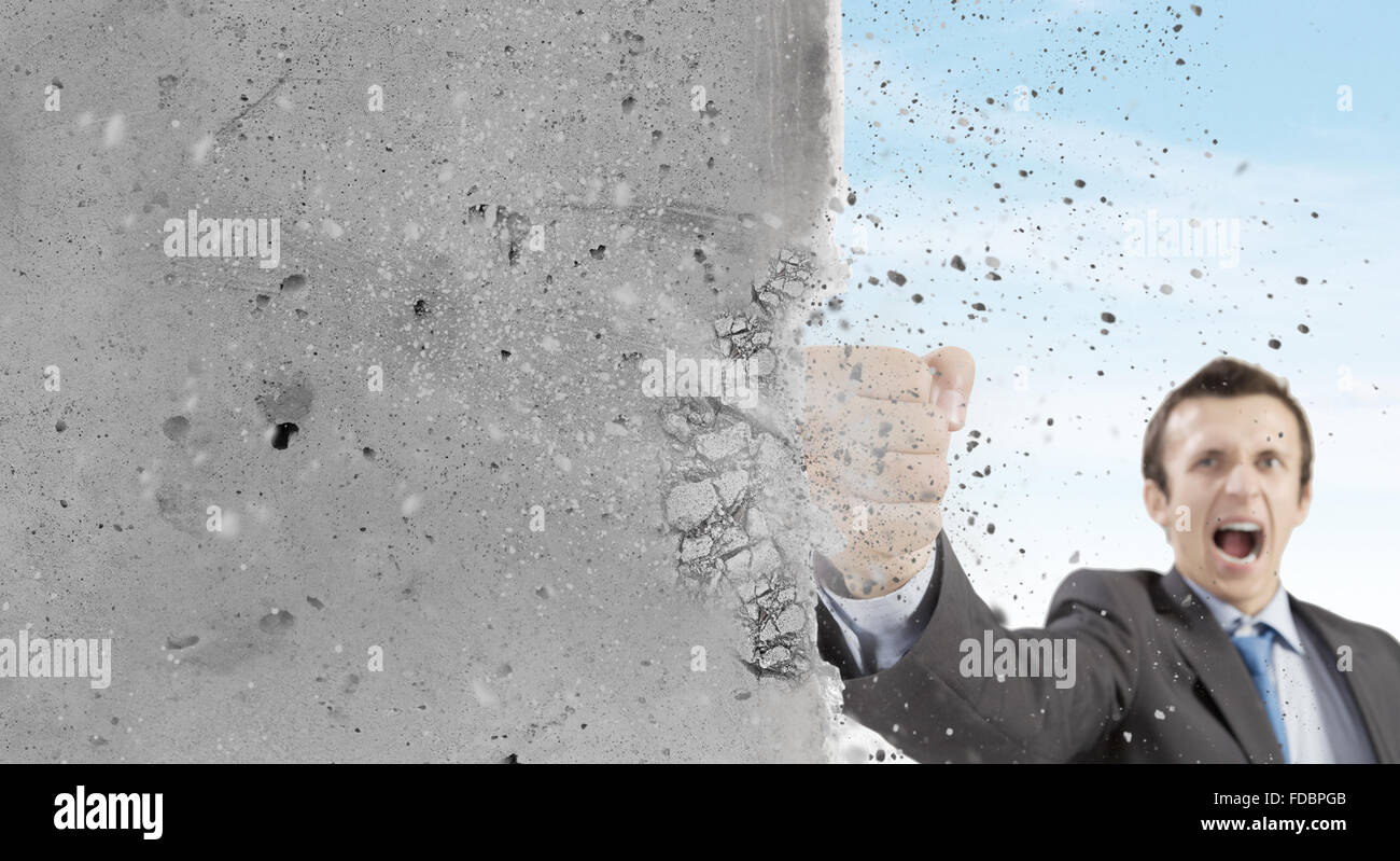Businessman breaking stone wall with karate punch Stock Photo - Alamy